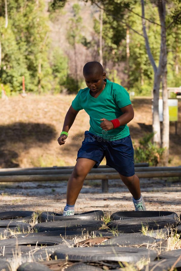 Boy Running Over Tyres during Obstacle Course Training Stock Photo ...