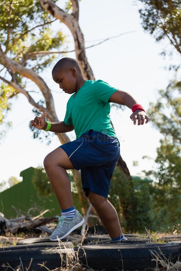 Boy Running Over Tyres during Obstacle Course Training Stock Photo ...