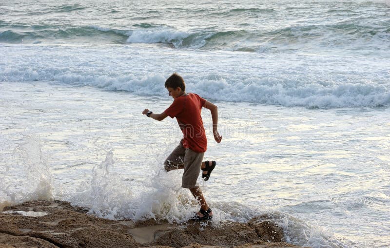 Boy runs along the shore stock photo. Image of coast - 240704792
