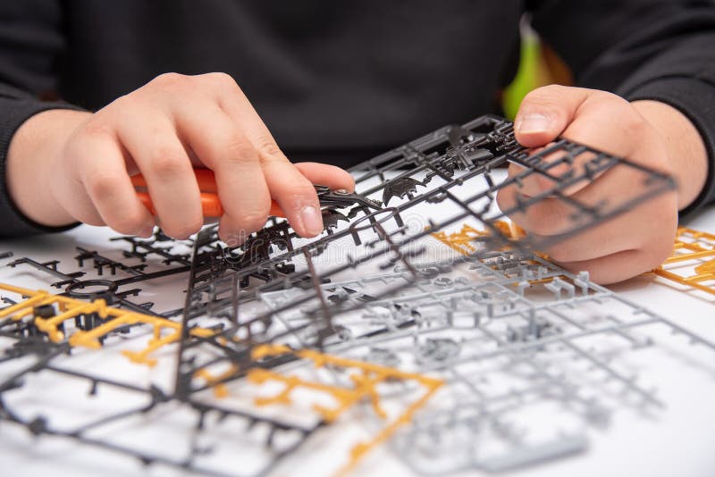A Boy`s Hand Assembling Plastic Models Using Tools. Stock Photo - Image ...