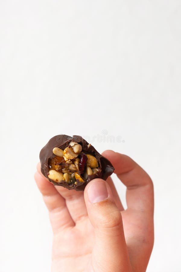 A Boy& X27;s Hand Holds a Bitten Craft Chocolate Candy with Nuts Stock ...