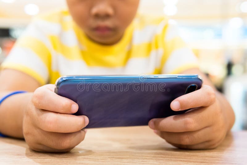 Boy`s playing smartphone stock photo. Image of screen - 128838030