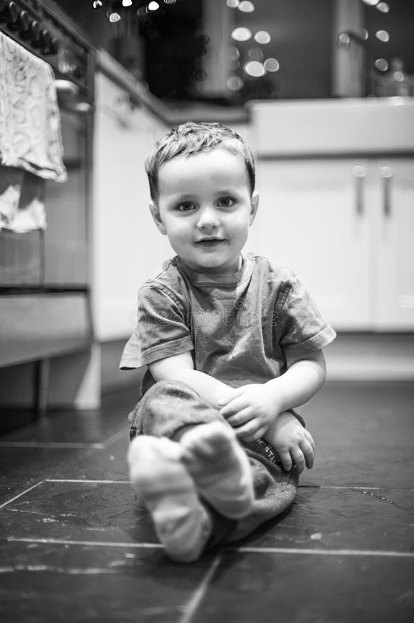 Boy sat on kitchen floor stock image. Image of indoors - 29571393