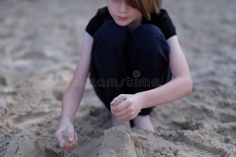 A Boy of School Age Playing in the Wet Sand Stock Image - Image of ...