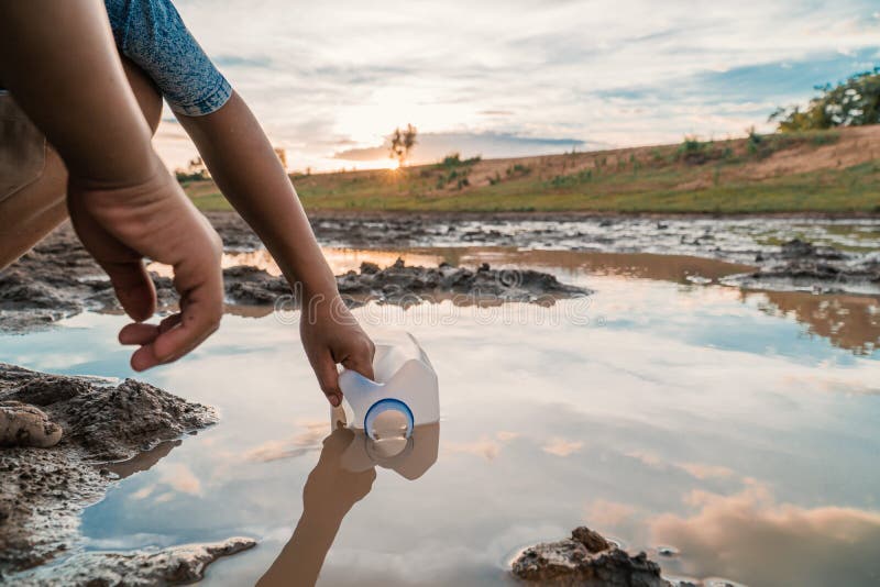 Boy Scooping Water from the Lake Stock Image - Image of world, water ...