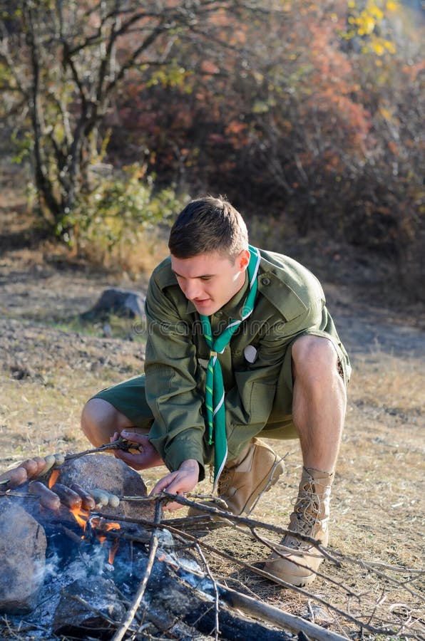 Boy Scout Cooking Sausages on Sticks Over Campfire Stock Image - Image ...