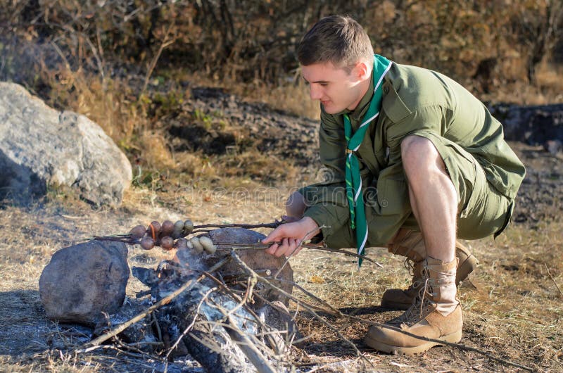 Boy Scout Cooking Sausages on Sticks Over Campfire Stock Photo - Image ...