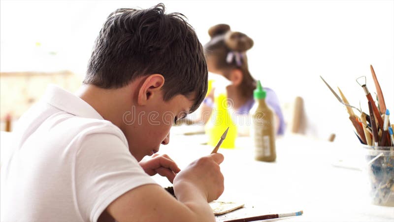 Boy Sculpts a Toy from Wet Clay in Art Workshop Using Special Tool ...