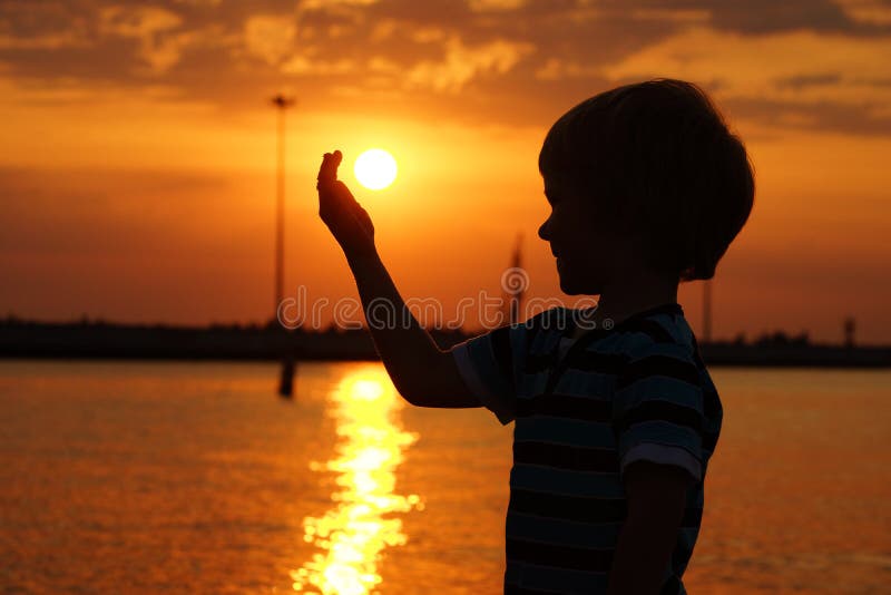 Boy by the sea at sunset stock photo. Image of family - 109279438