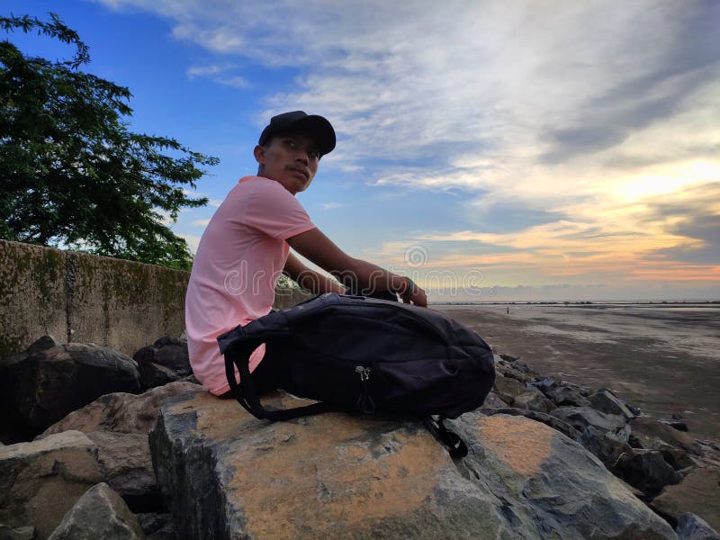 Boy Setting Alone at Beach in Evening of Sunset with Black Bag Stock ...