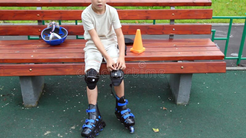 Boy Sits on Bench in Rollers Standing and Dresses Stock Video - Video ...