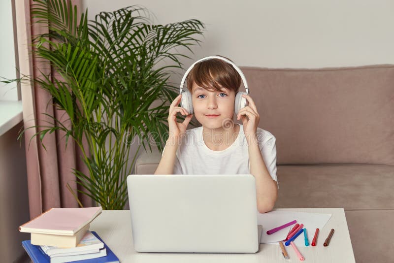 The Boy Sits on the Couch and Does Homework while Sitting at the Table ...