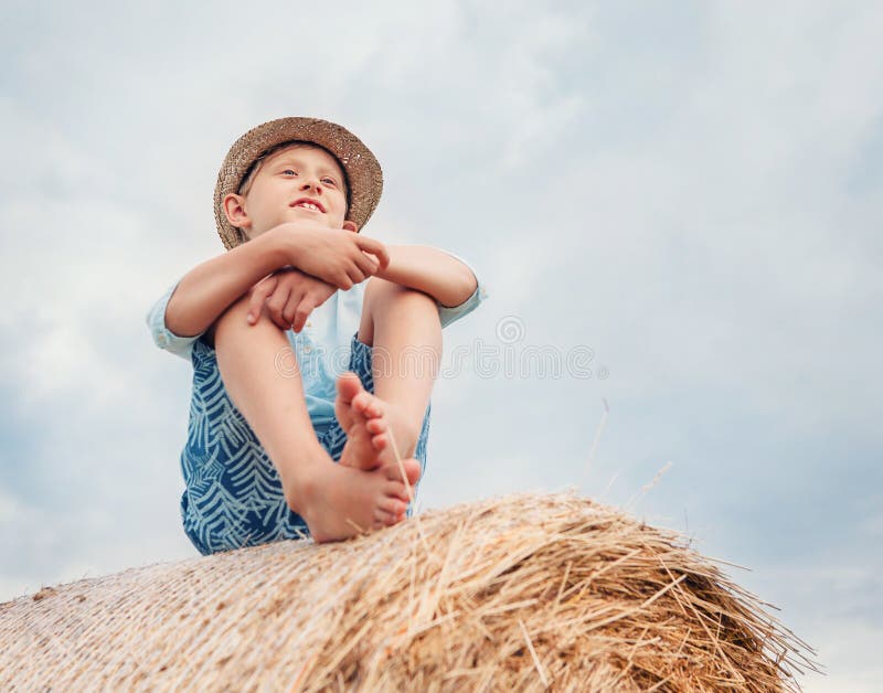 Boy Sits on the Haystack Top with Sunny Sky Background Stock Photo ...