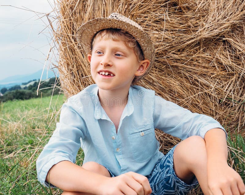Boy Sits on the Haystack Top Stock Photo - Image of happy, countryside ...