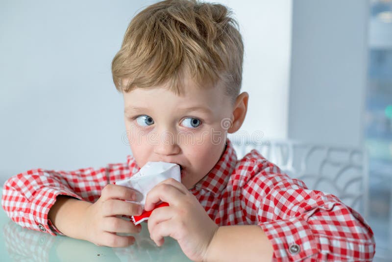 Boy Sits at the Table and Eats a Chocolate Bar Stock Image - Image of ...