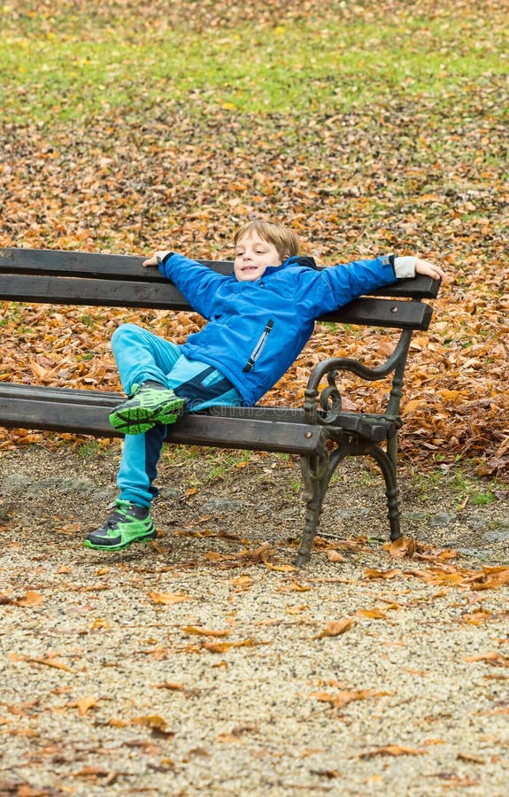 Boy sitting on bench stock photo. Image of colour, resting - 81403390