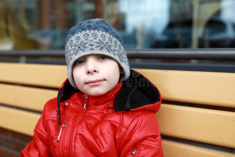 Boy sitting on bench stock image. Image of lonely, childhood - 143850437