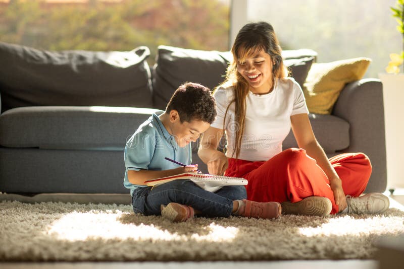 Boy Sitting on a Carpet with His Mother Stock Photo - Image of notebook ...