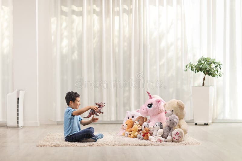 Boy Sitting on a Carpet and Playing with a Dinosaur Stock Photo - Image ...