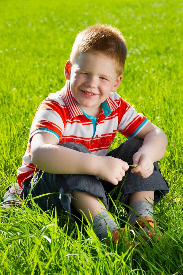 Boy Sitting on Field of Grass Stock Image - Image of play, beautiful ...