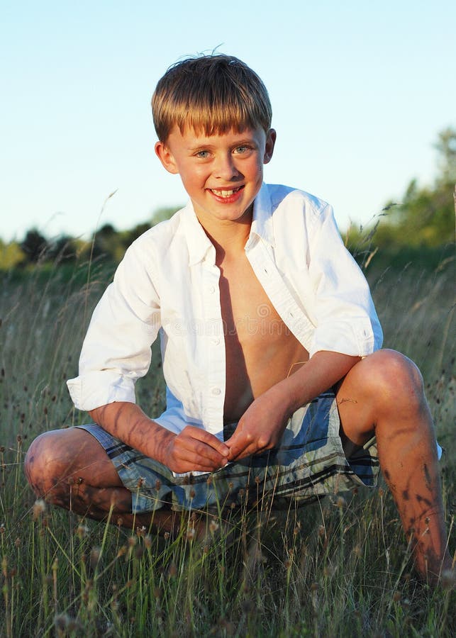 Boy Sitting in Field of Grass - Vertical Stock Image - Image of field ...