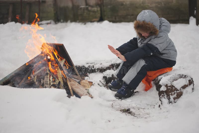 Boy Sitting by Fire in the Street Stock Photo - Image of nature, warm ...