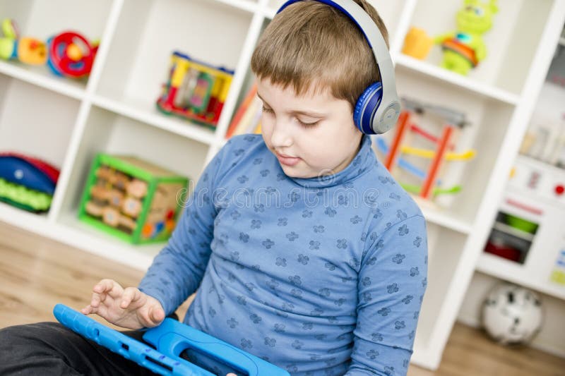 Boy Sitting on the Floor and Gaming with Blue IPad. Stock Image - Image ...