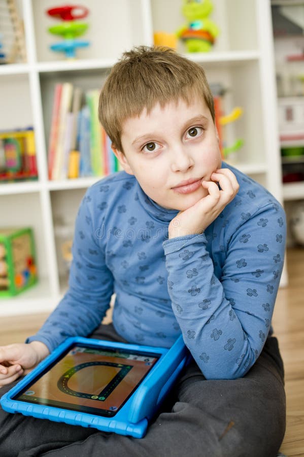 Boy Sitting on the Floor and Gaming with Blue IPad. Stock Image - Image ...