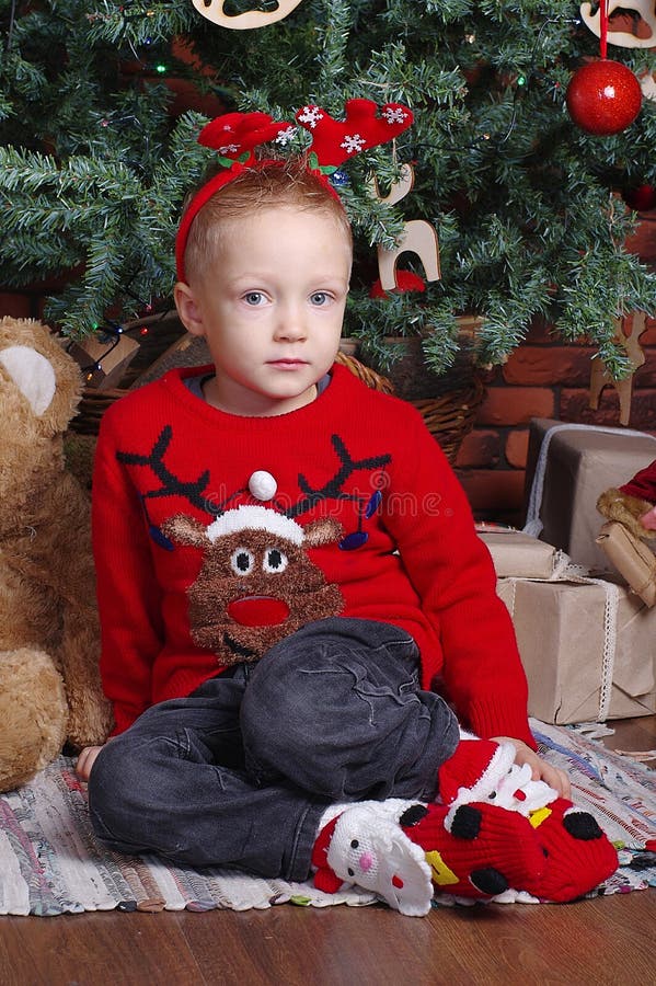 Boy Sitting in Front of Critmass Tree with Toy Horns Stock Photo ...