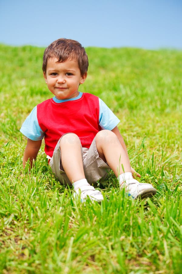 Boy sitting on grass stock photo. Image of playful, person - 20885278