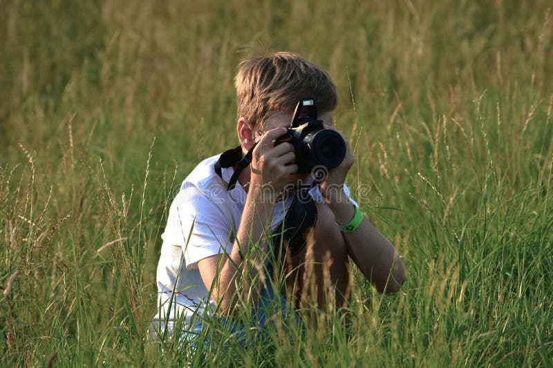 Boy Sitting in the Grass with a Camera Stock Photo - Image of camera ...