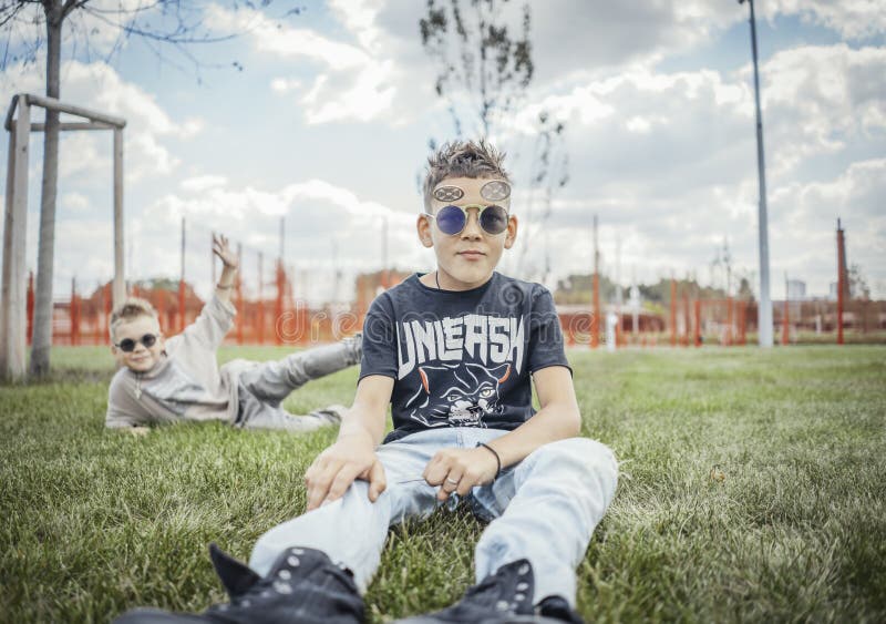 Boy Sitting on Green Meadow in Park and Looking at Viewer. Stock Image ...