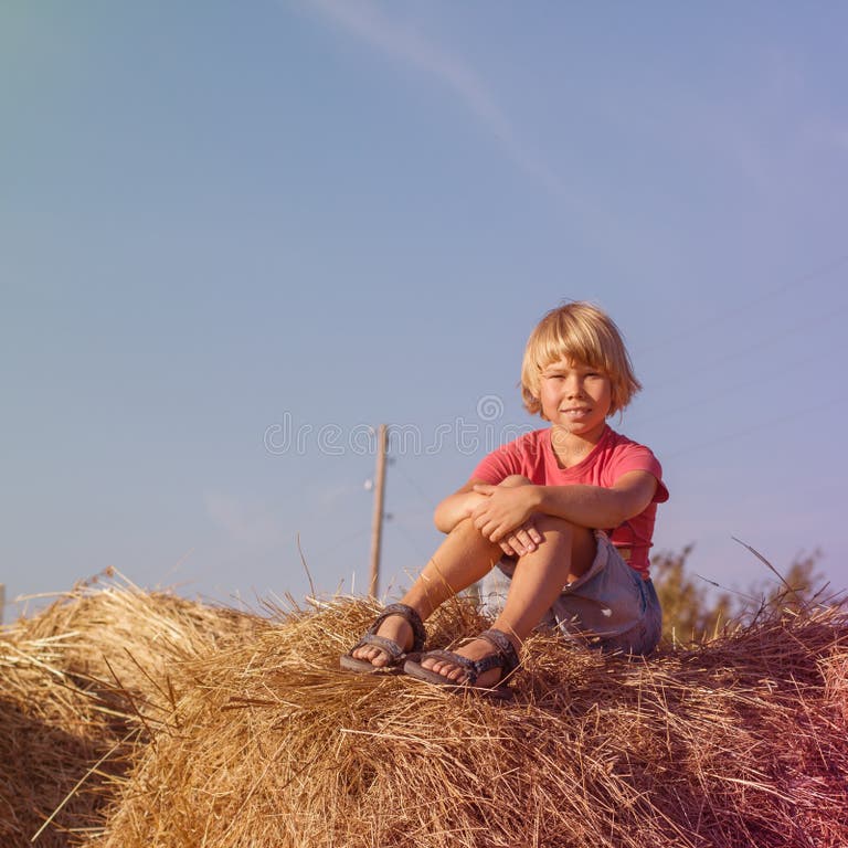 Boy sitting on a haystack stock image. Image of outdoor - 43624481