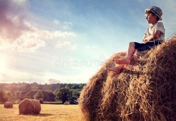 Boy Sitting on a Haystack Watching the Sunset Stock Image - Image of ...