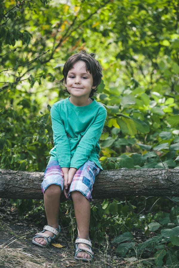 The Boy is Sitting on a Log. Stock Photo - Image of country, baby ...