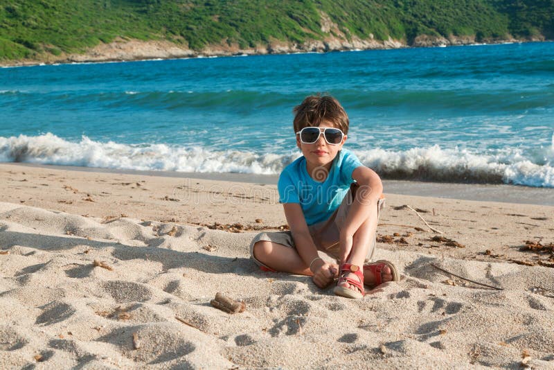 Boy sitting on the sand stock photo. Image of vacation - 26154516