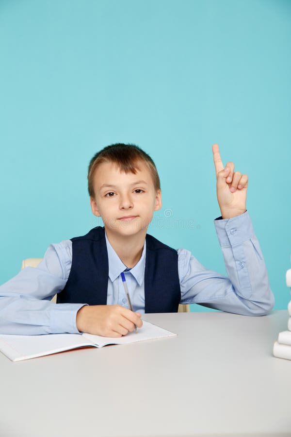 Boy Sitting at the Table and Pointing Something Up. Stock Image - Image ...