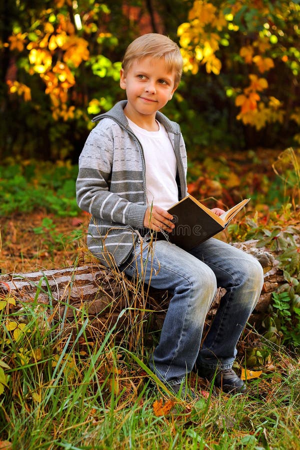 Boy Sitting in the Woods on a Log Stock Image - Image of rays, autumn ...