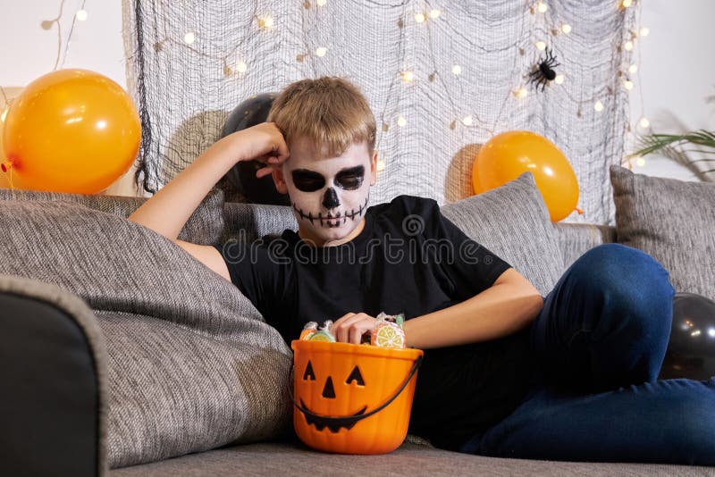 A Boy in Skeleton Makeup Pulls Out Candy from a Halloween Party. Stock ...