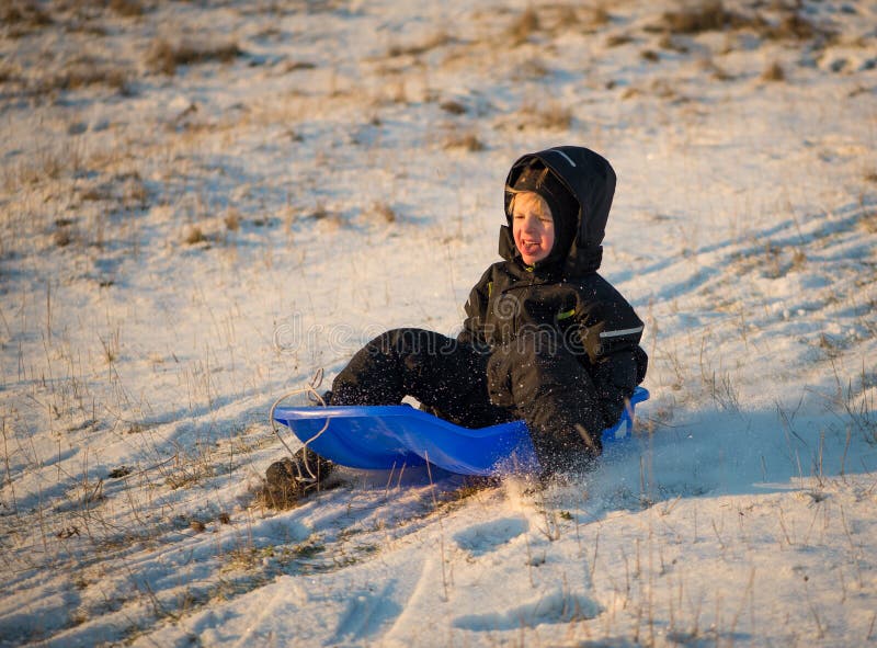 Boy Sledding in Sunset Trying To Catch Snow Drift Stock Image - Image ...