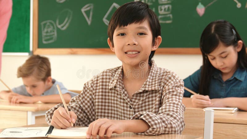 Boy Smiling To Camera while Student Writing Answer in Answer Sheet ...