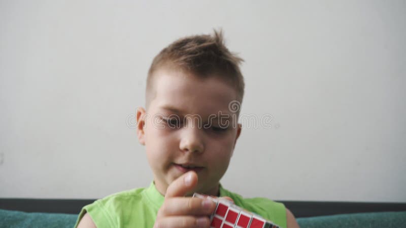 Boy Solving the Rubiks Cube. Young Boy Collects Rubik S Cube in the ...