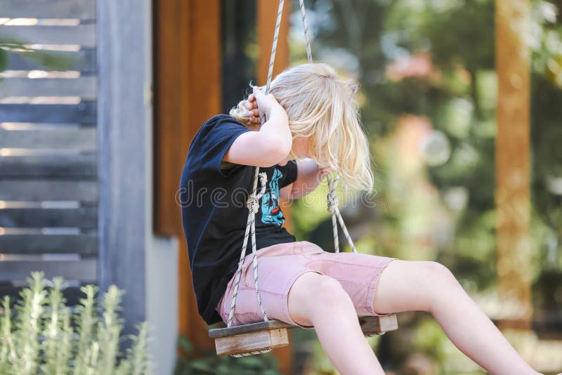 Boy Spinning on Backyard Swing on a Tranquil Patio on a Beautiful ...