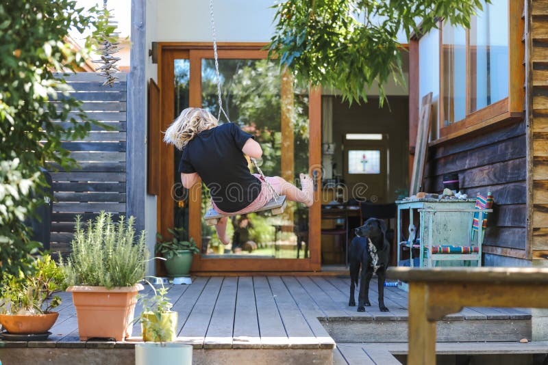 Boy Spinning on Backyard Swing on a Tranquil Patio on a Beautiful ...