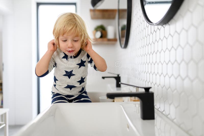 Boy Spitting Toothpaste and Water after Brushing His Teeth. Morning ...