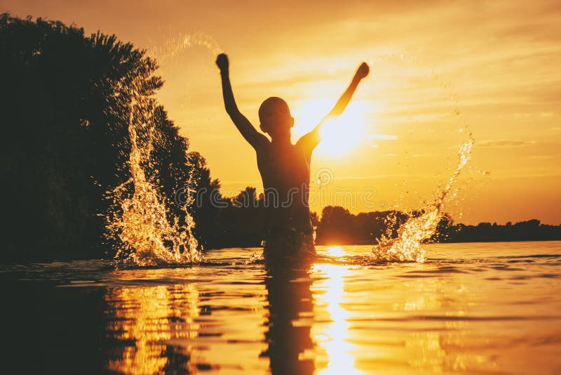 Boy Splashing in the Water at Sunset Stock Image - Image of hand ...