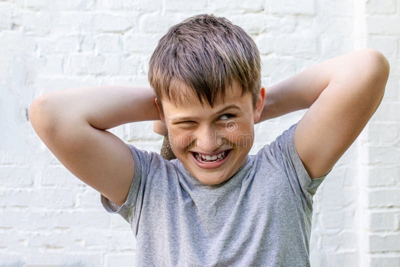 Boy Squints One Eye and Swings, Holding the Object Behind His Back ...