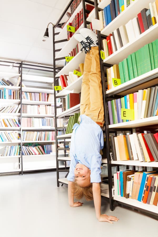 Boy Standing on Arms Upside Down in Library Stock Image - Image of ...
