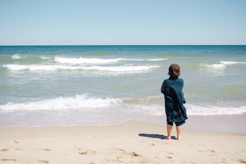 Boy standing on the beach stock image. Image of sand - 41094833