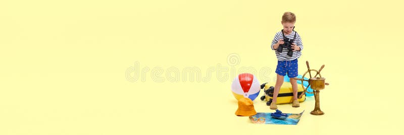 Boy Standing with Binoculars, Surrounded by Beach Ball, Suitcase ...